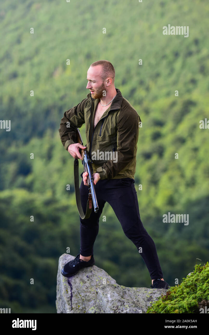 Illegal hunting. Poaching concept. Poacher stand on edge of cliff. Man ...