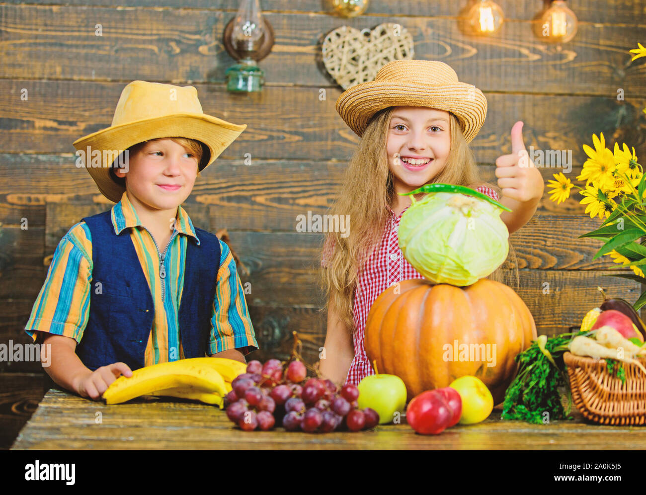 Celebrate harvest holiday. Children play vegetables wooden background ...