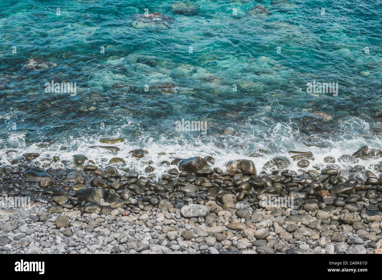 ocean waves on stone beach with black pebbles Stock Photo - Alamy