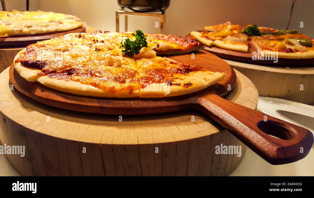 Pizza on the wooden plate that consist of many of topping such as ...