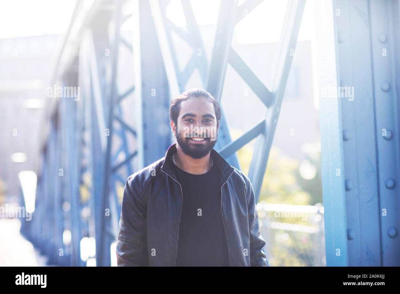 young man with braid and beard walking on a steel bridge Stock Photo ...
