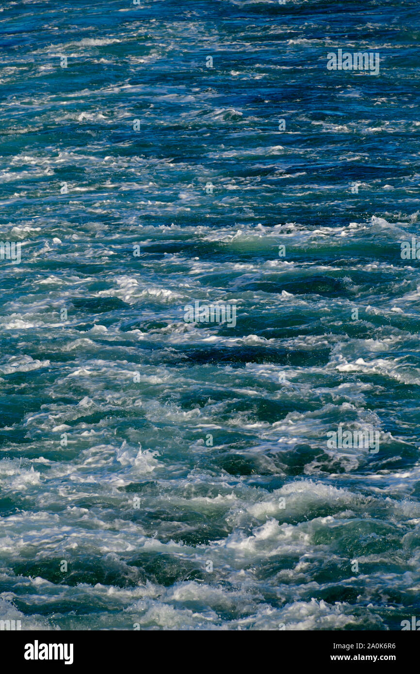 A vertical image of ocean water being displaced by a boat traveling ...