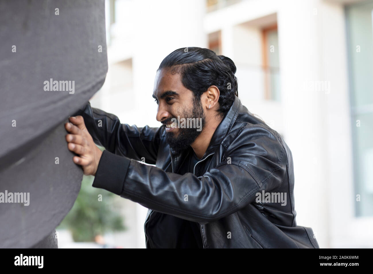 young man pushing a wall Stock Photo - Alamy