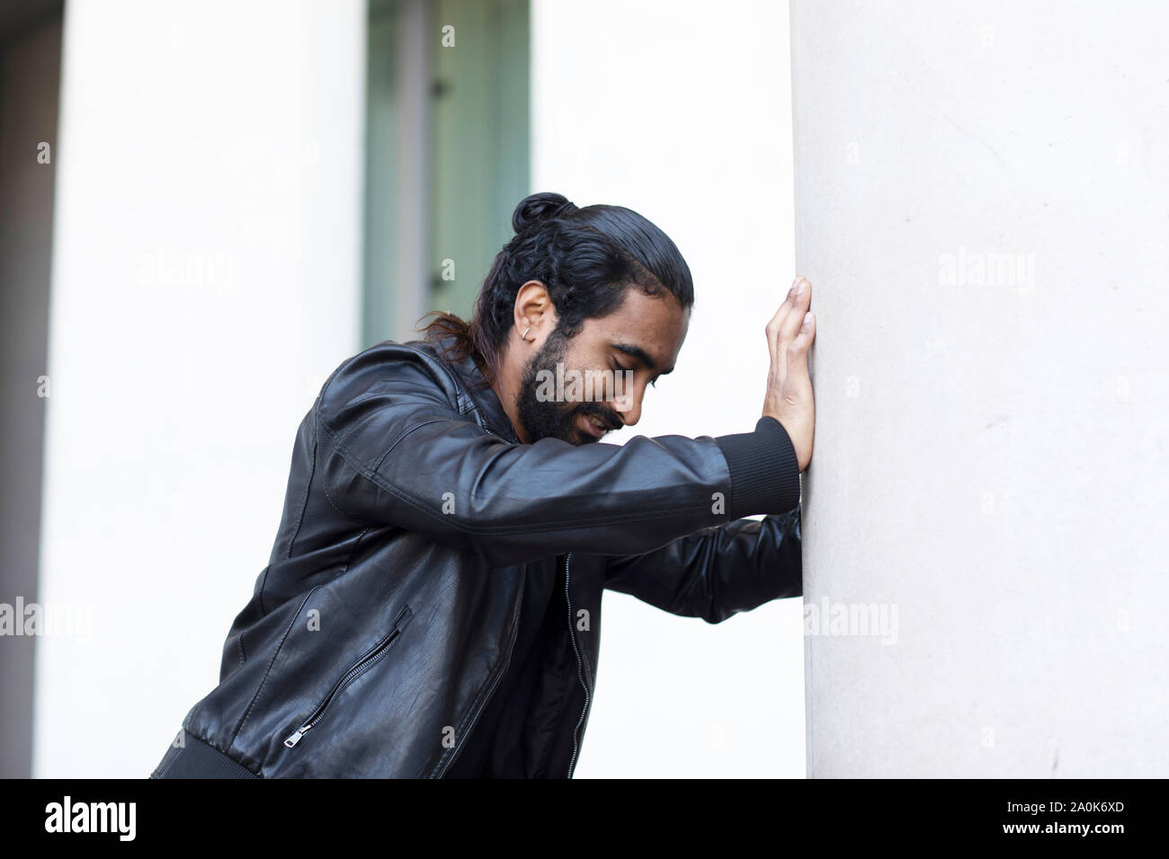young man pushing a wall Stock Photo - Alamy