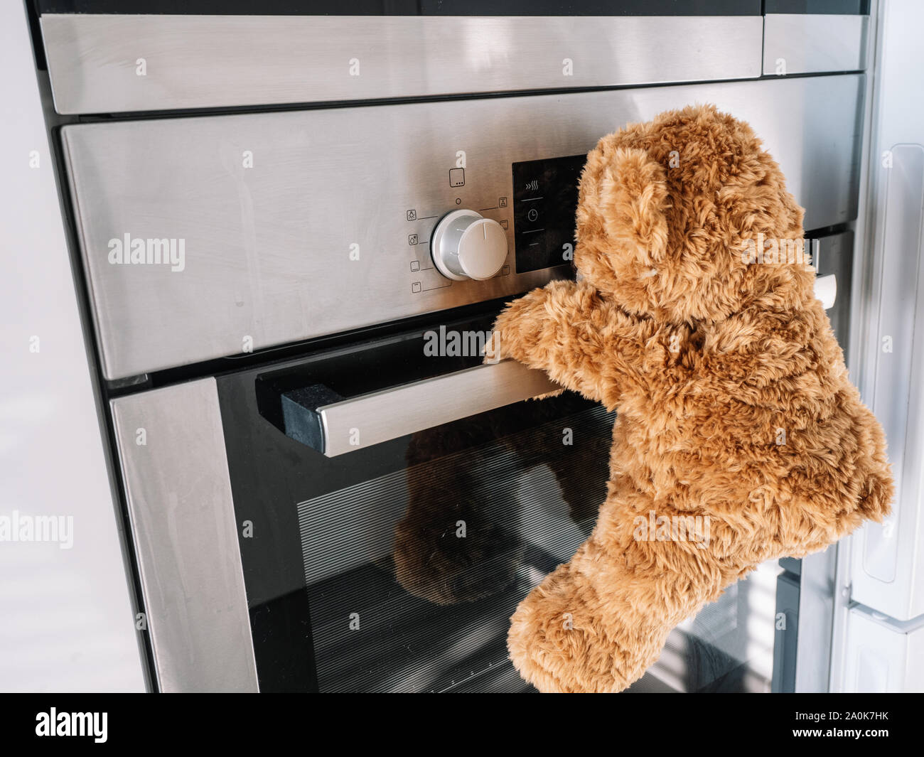 Brown teddy bear, is watching how the oven goes in the kitchen Stock ...
