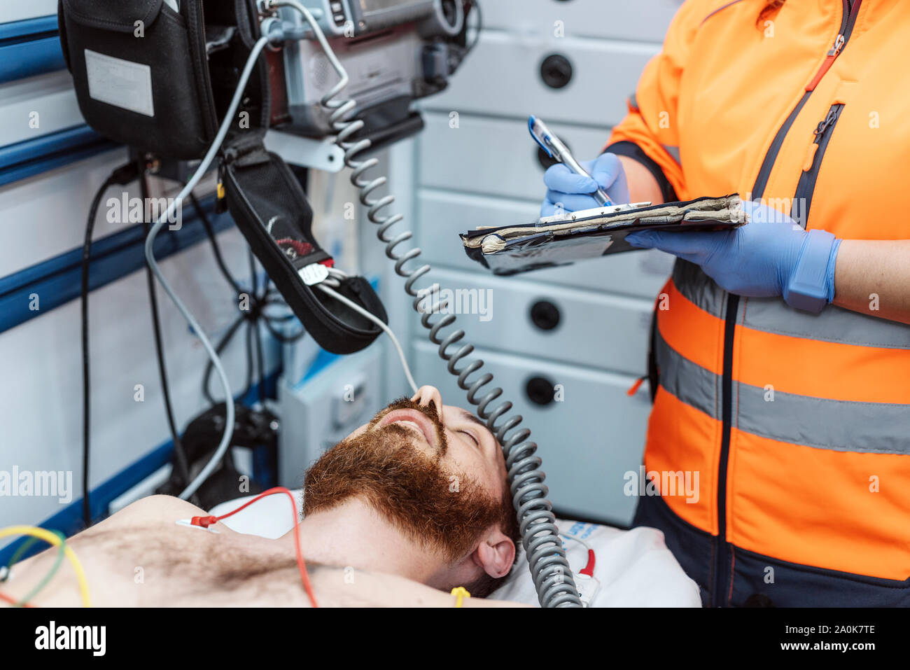 Doctor writing medical report to clipboard at hospital, urgency room ...