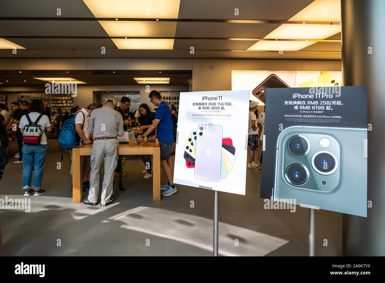 Customers look at Apple's new iPhone 11 series smartphones at an Apple ...