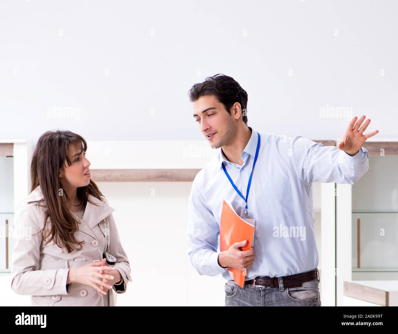 The salesman explaining to woman customer at furniture store Stock ...