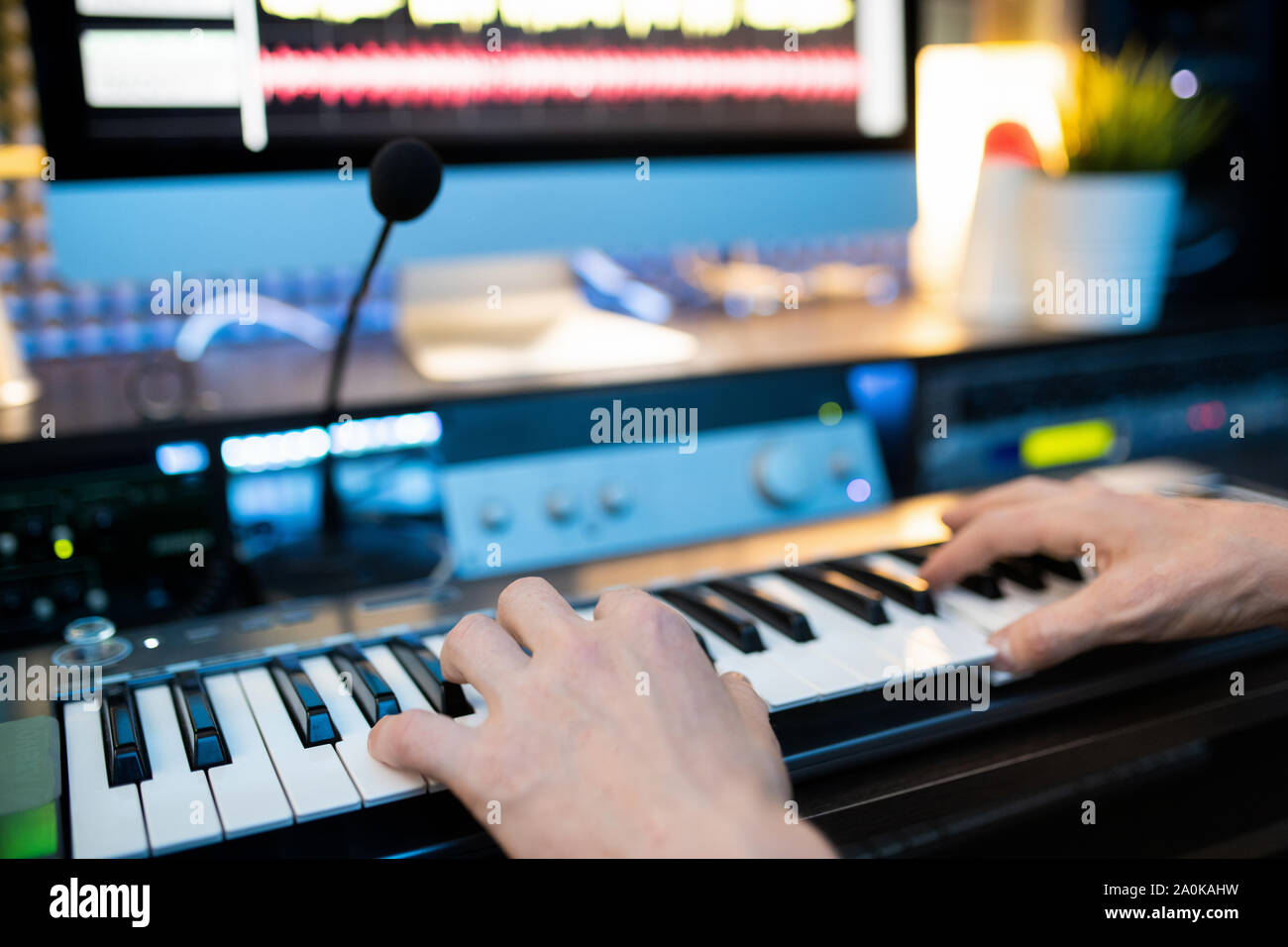Hands of young musician pressing keys of piano keyboard in recording ...