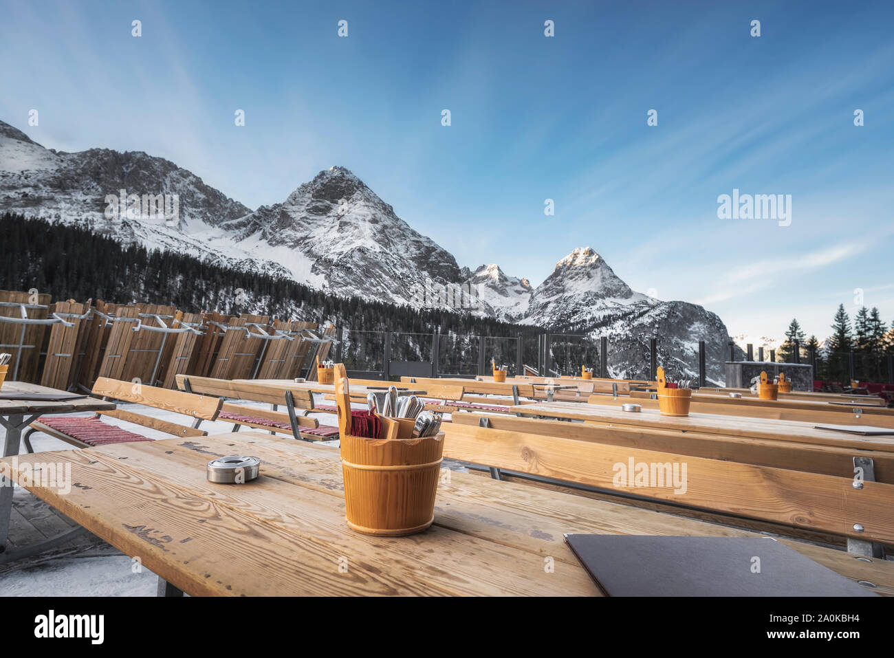 Winter scenery with an outdoor restaurant with wood tables and snow ...