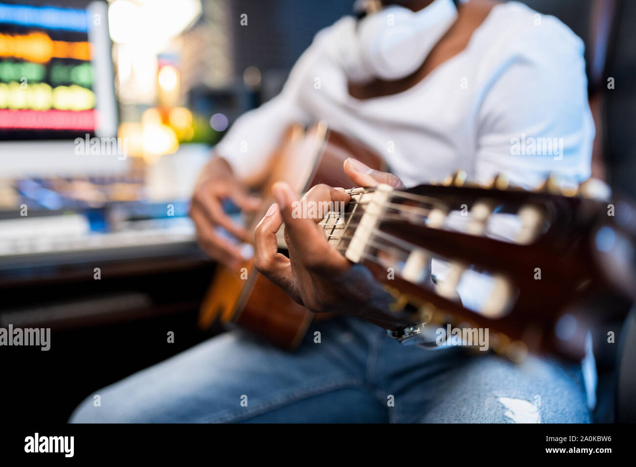 Hands of young musician of African ethnicity on strings of acoustic ...