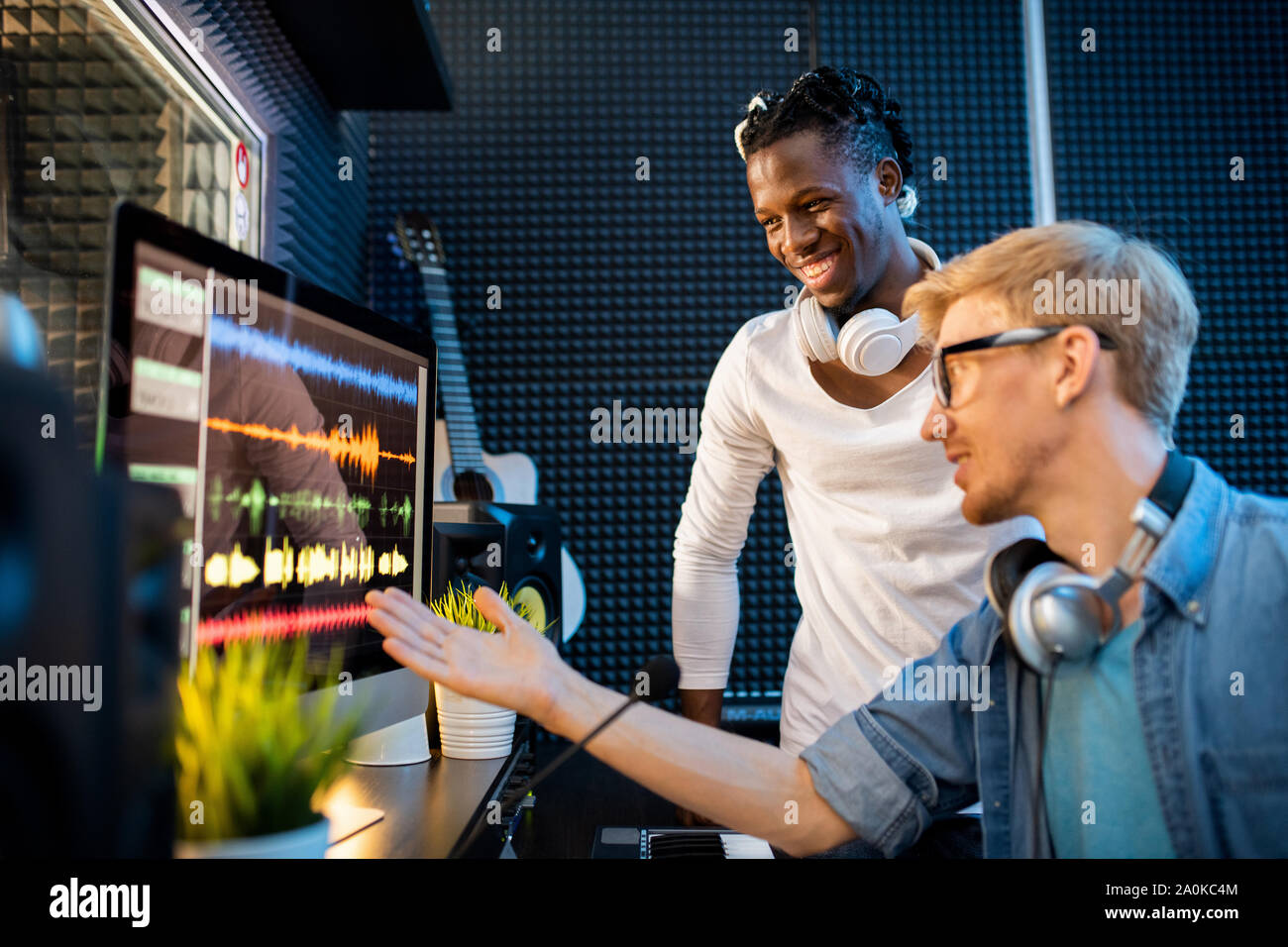 Young musician or producer showing African man group of sound waveforms ...