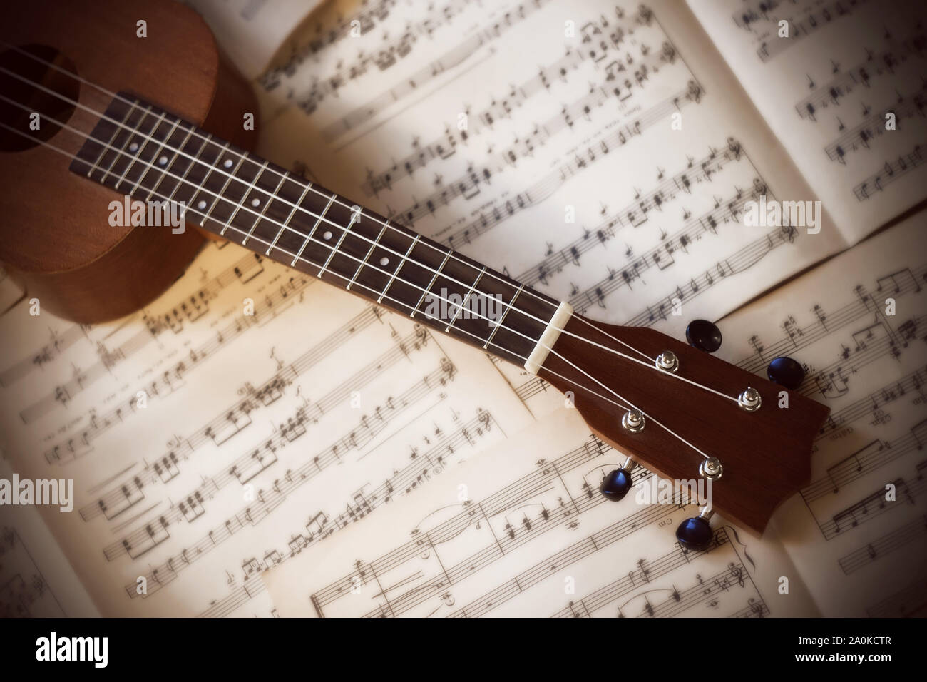 A small four-stringed ukulele with nylon strings lies on old white ...