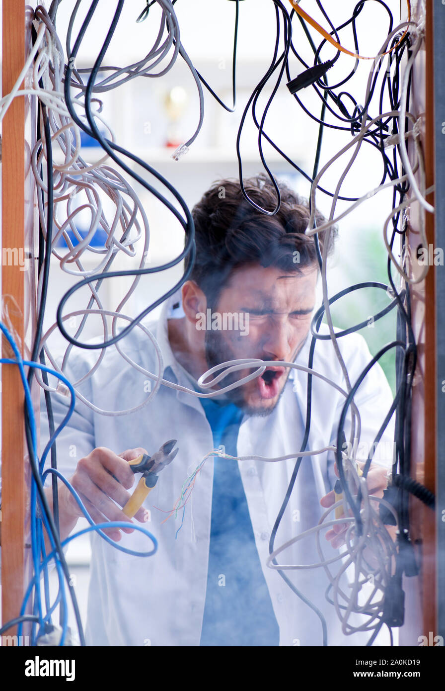 The electrician trying to untangle wires in repair concept Stock Photo ...