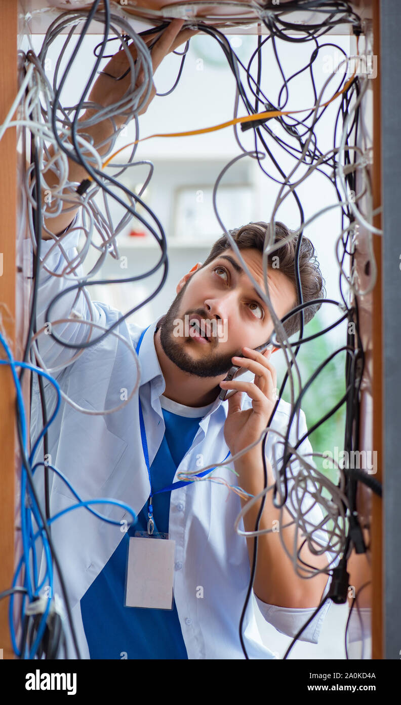 The electrician trying to untangle wires in repair concept Stock Photo ...