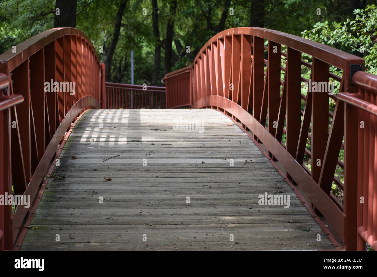 Pretty red bridge with tree canopy Stock Photo - Alamy