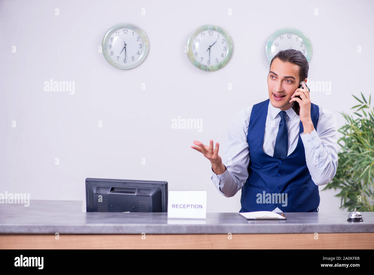 The young man receptionist at the hotel counter Stock Photo - Alamy