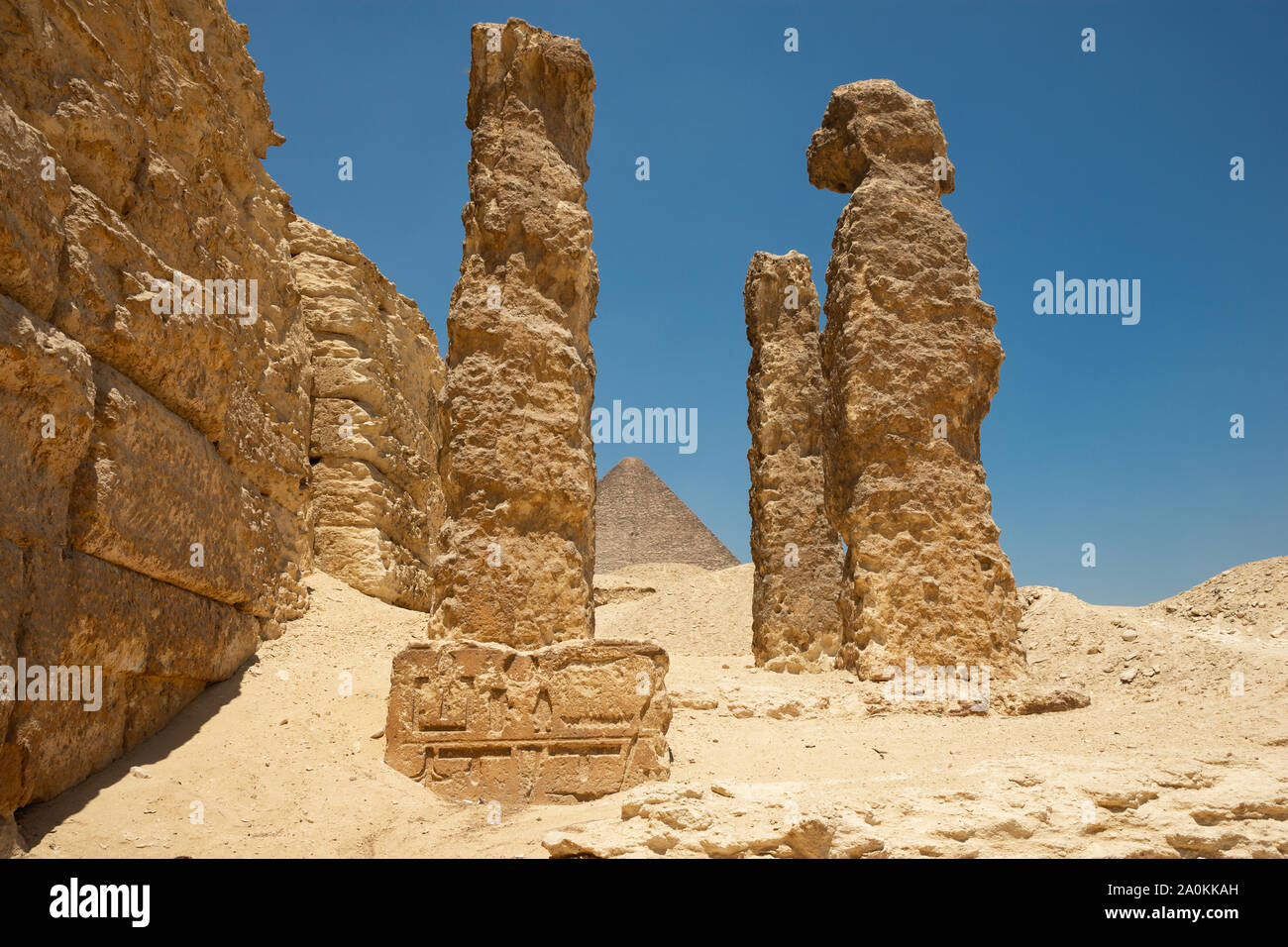 Khufu pyramid is seen from ancient ruins. Pillars and stone fragment ...