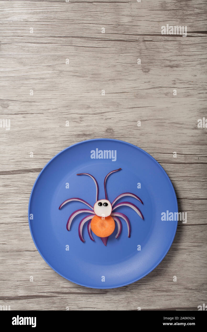 Idea of making a spider from onion and carrot on blue plate Stock Photo ...