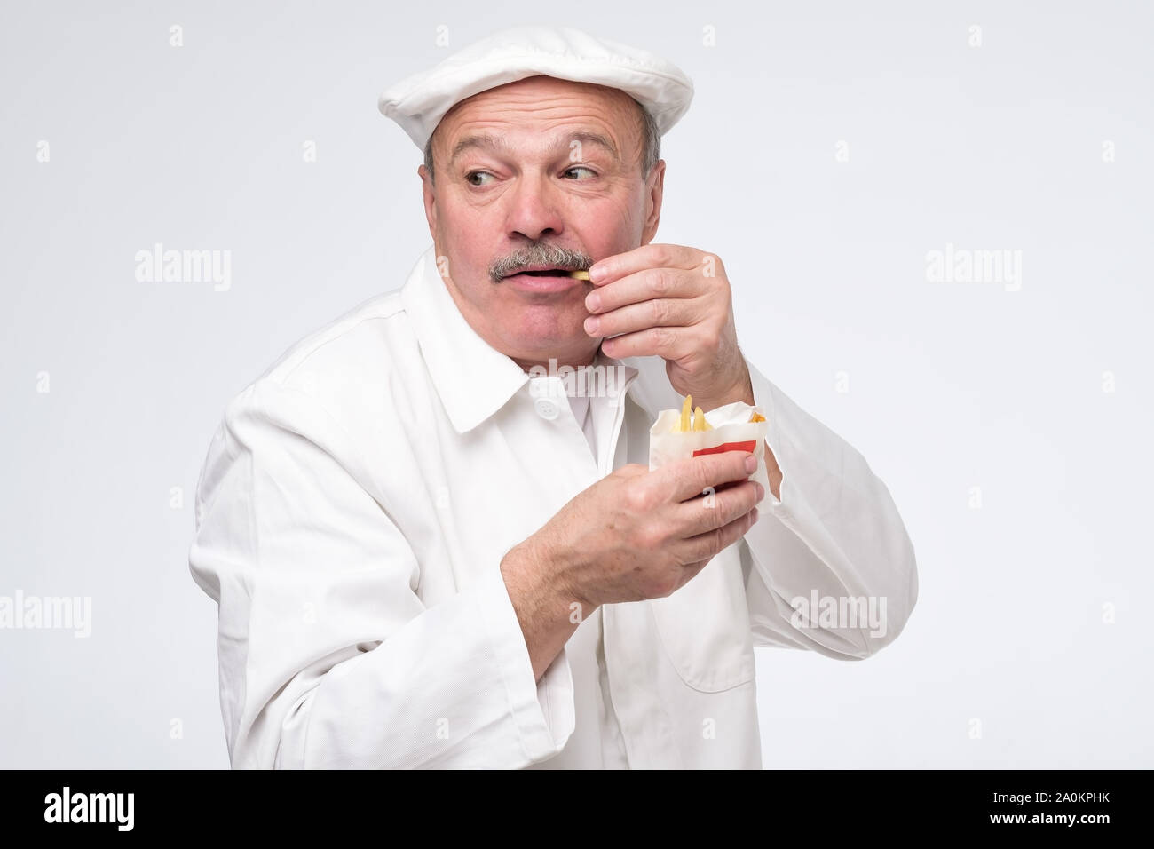 Funny hungry bearded male cook chef eating junk food isolated on white ...