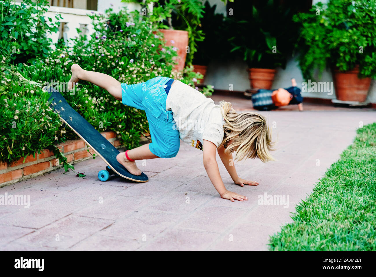 5 year old boy practicing skate in his backyard, stumbling and falling ...