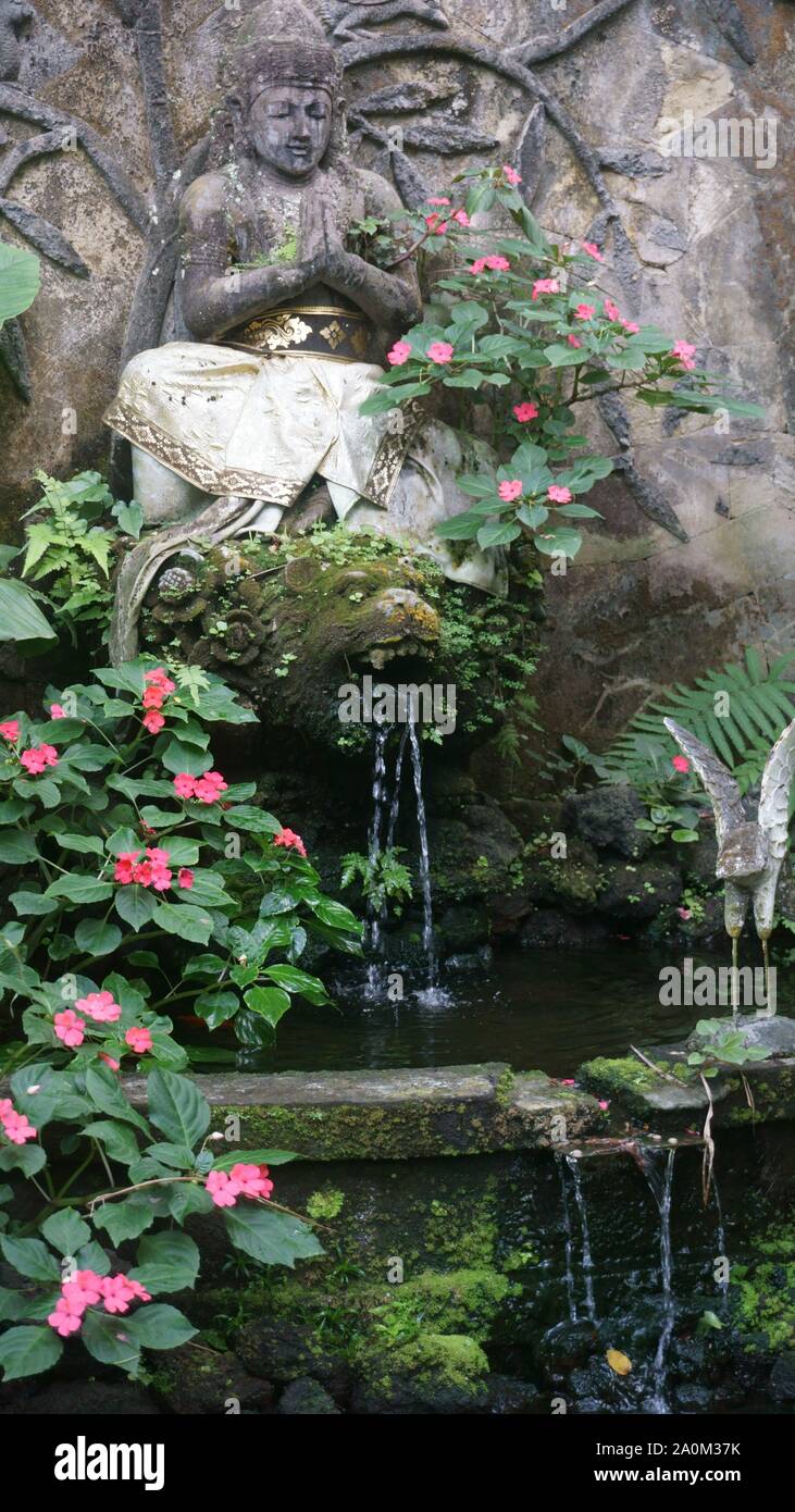 statue with flowing water to a pond Stock Photo - Alamy