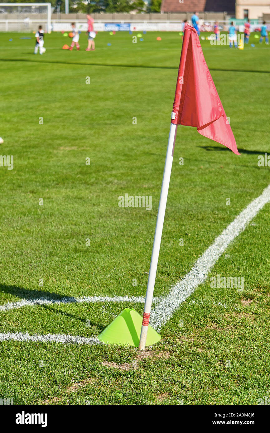 Corner post on a soccer pitch with yellow cone and out of focus ...