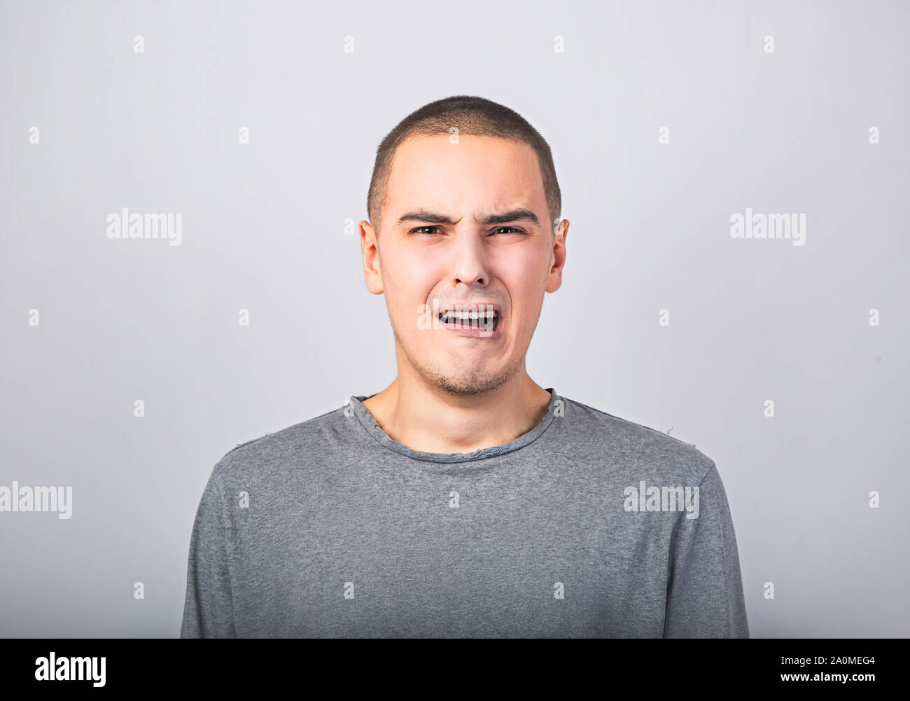 Unhappy crying man with grimacing face. Closeup studio portrait on grey ...