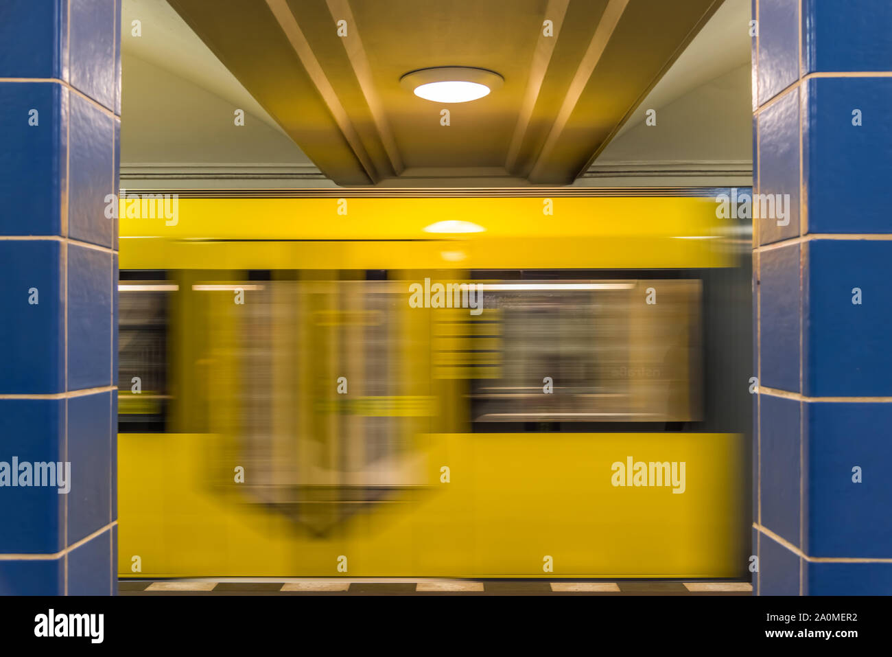 The yellow subway in the blue subway station Boddinstrasse Stock Photo ...
