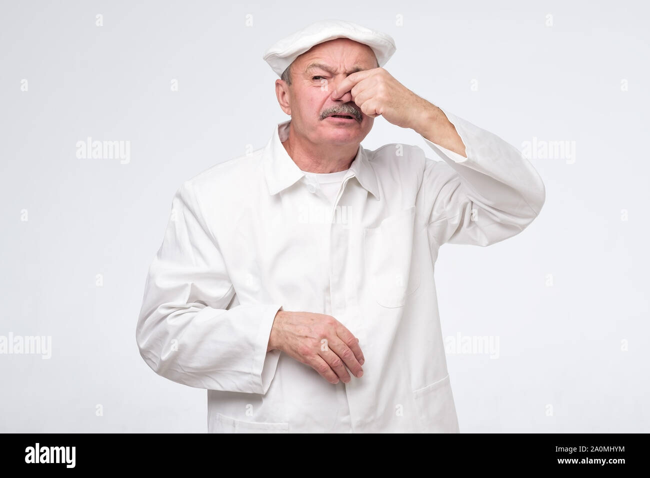 Chef cook covering nose because of disgusting odor. Unpleasant smell of ...