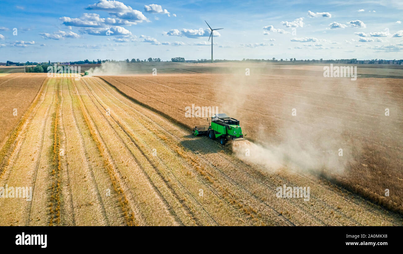 Combine harvester on field and wind turbine hi-res stock photography ...