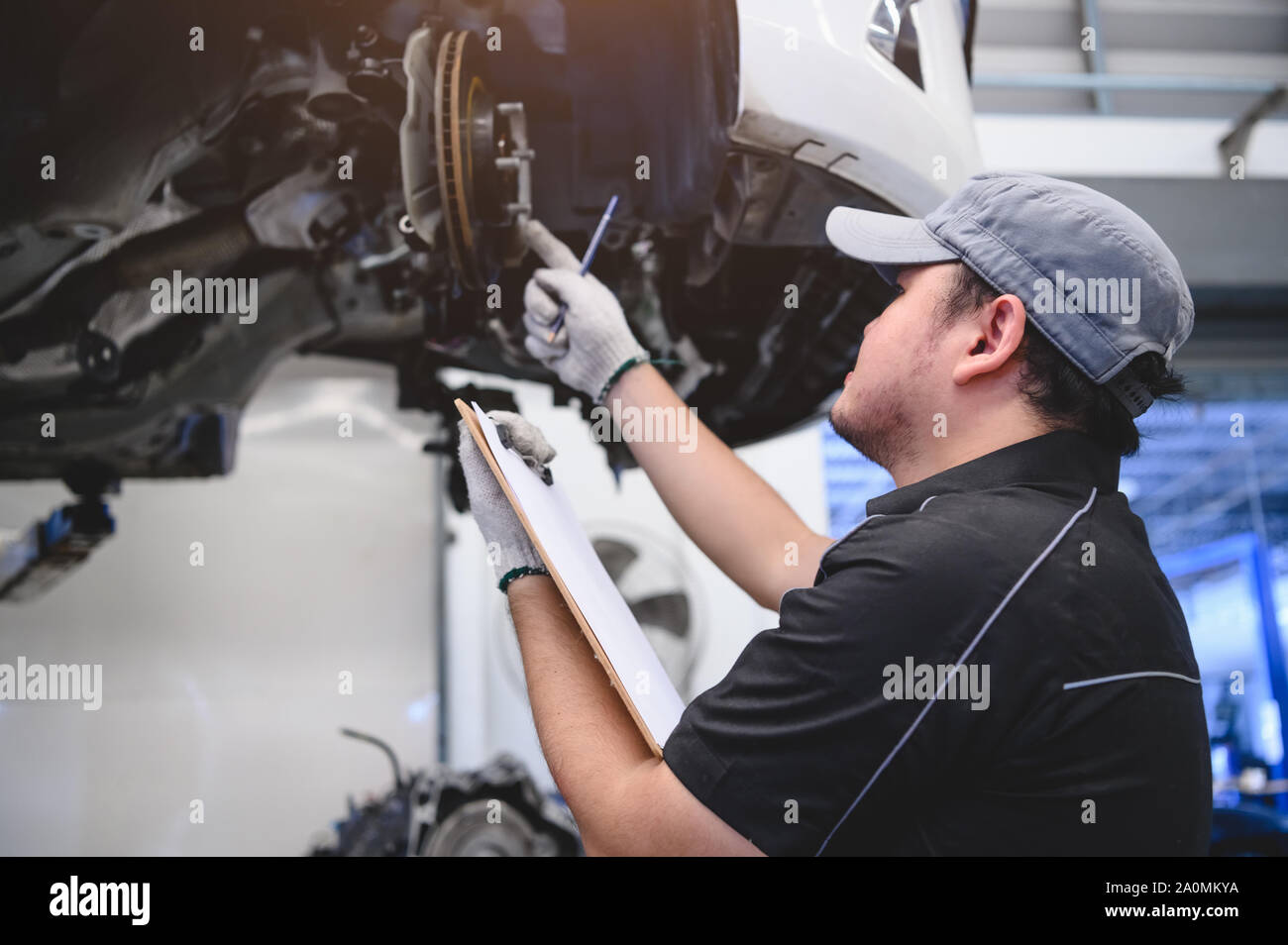 Asian male car technician car maintenance for customers according to ...