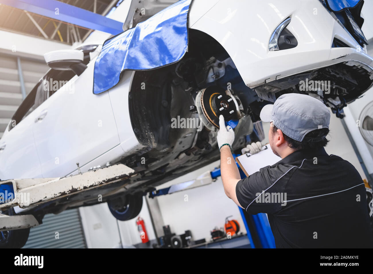 Asian male car technician car maintenance for customers according to ...