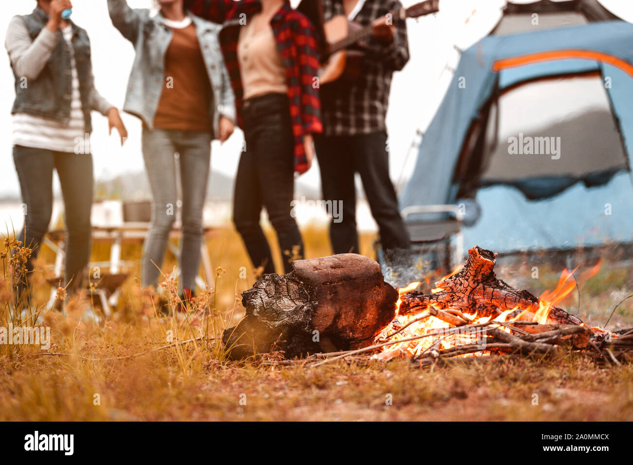 Closeup of campfire and friendship dancing to beat of the music for ...