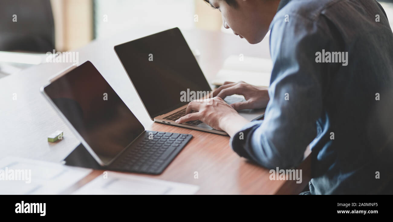Young UX web developer working on the smartphone templates on laptop ...