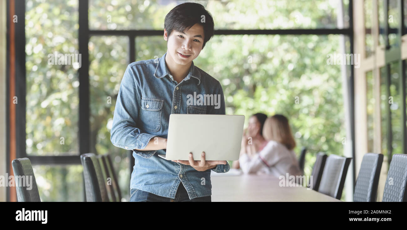 Young male professional UX web developer standing in the meeting room ...