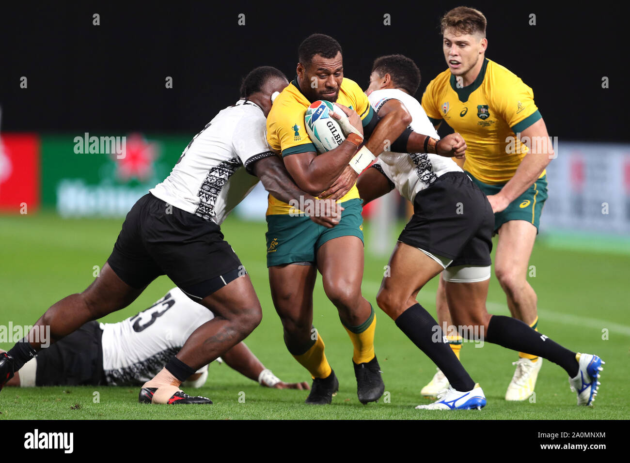 Australia's Samu Kerevi (centre) is tackled by Fiji's Peni Ravai (left ...