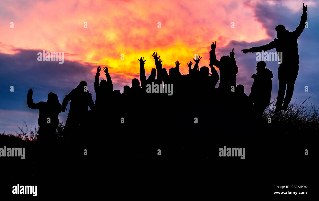 Silhouette, group of happy people jumping in sunset Stock Photo - Alamy