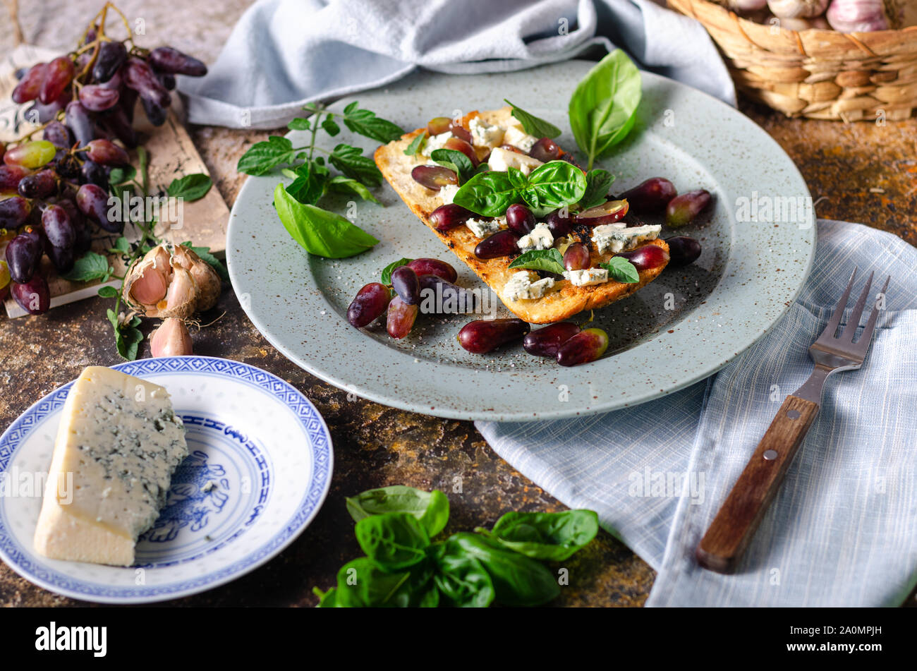 Morning breakfast with crispy bruschetta, blue cheese and grapes Stock ...