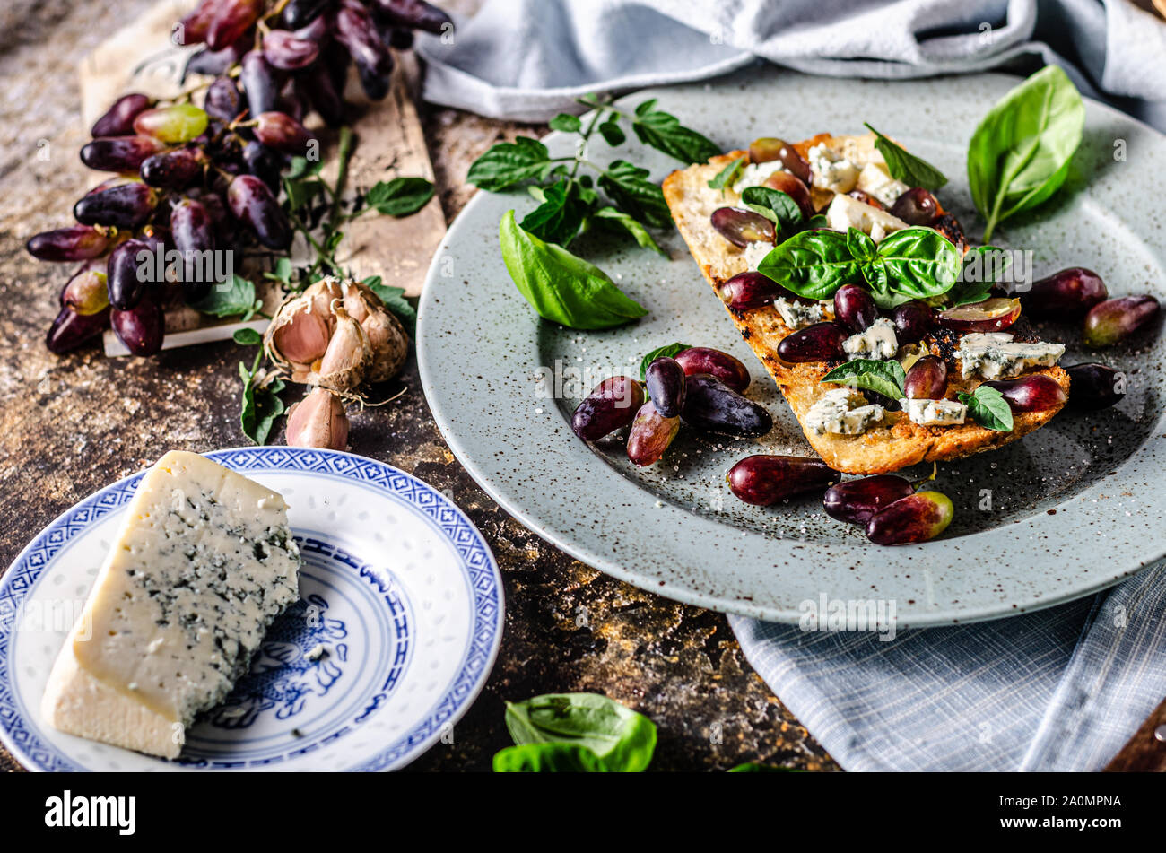 Morning breakfast with crispy bruschetta, blue cheese and grapes Stock ...