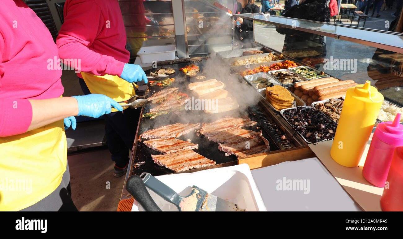 cook with a latex glove for hygiene while cooking sausages in an ...