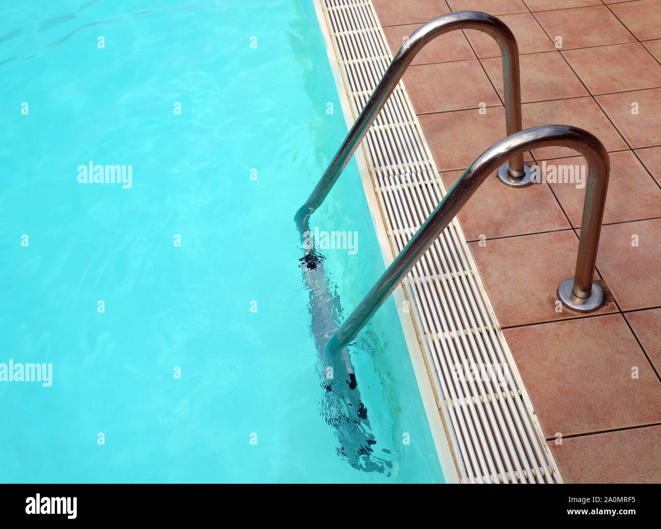 Detail of stepladder and blue water of a clear swimming pool without ...