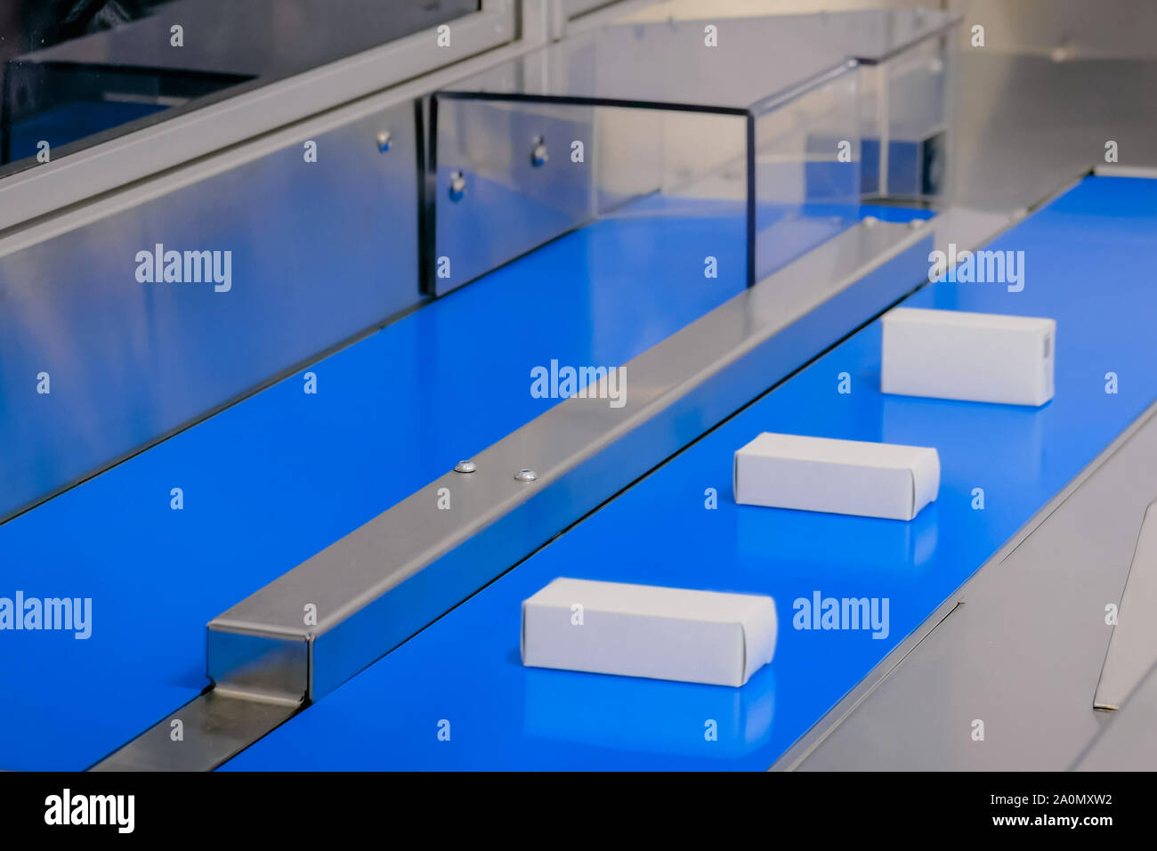 Automatic sorting conveyor system - moving white small cardboard boxes ...