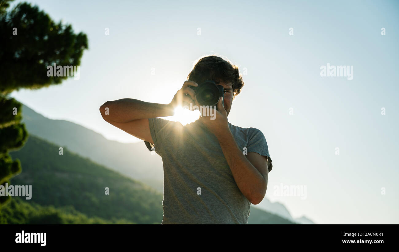 Low angle view of male photographer taking photo directly at you ...