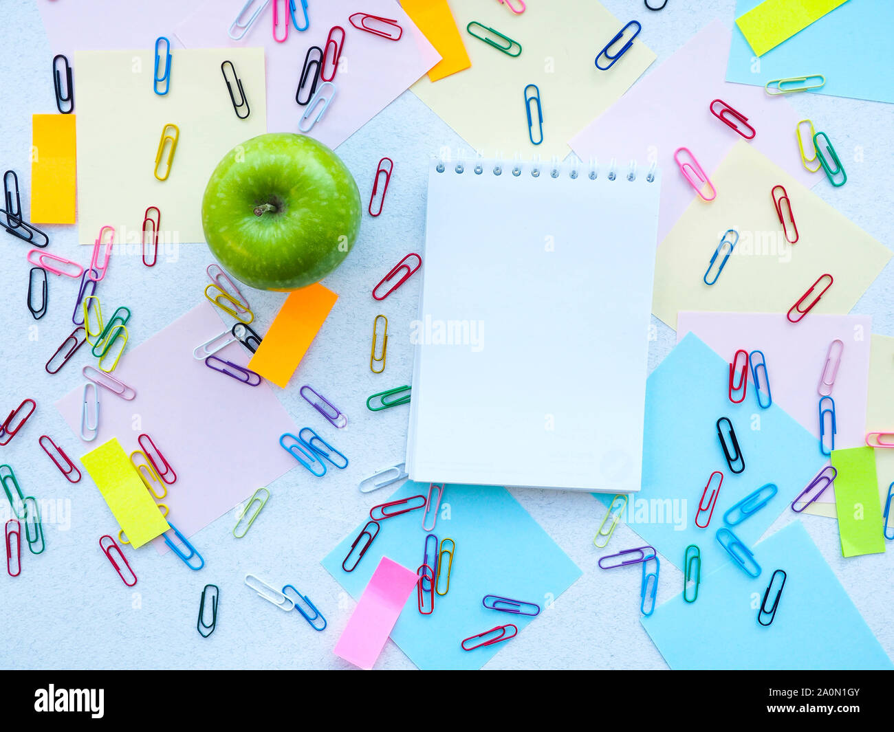 Apple, Notepad, paper clips, stickers on the table Stock Photo - Alamy