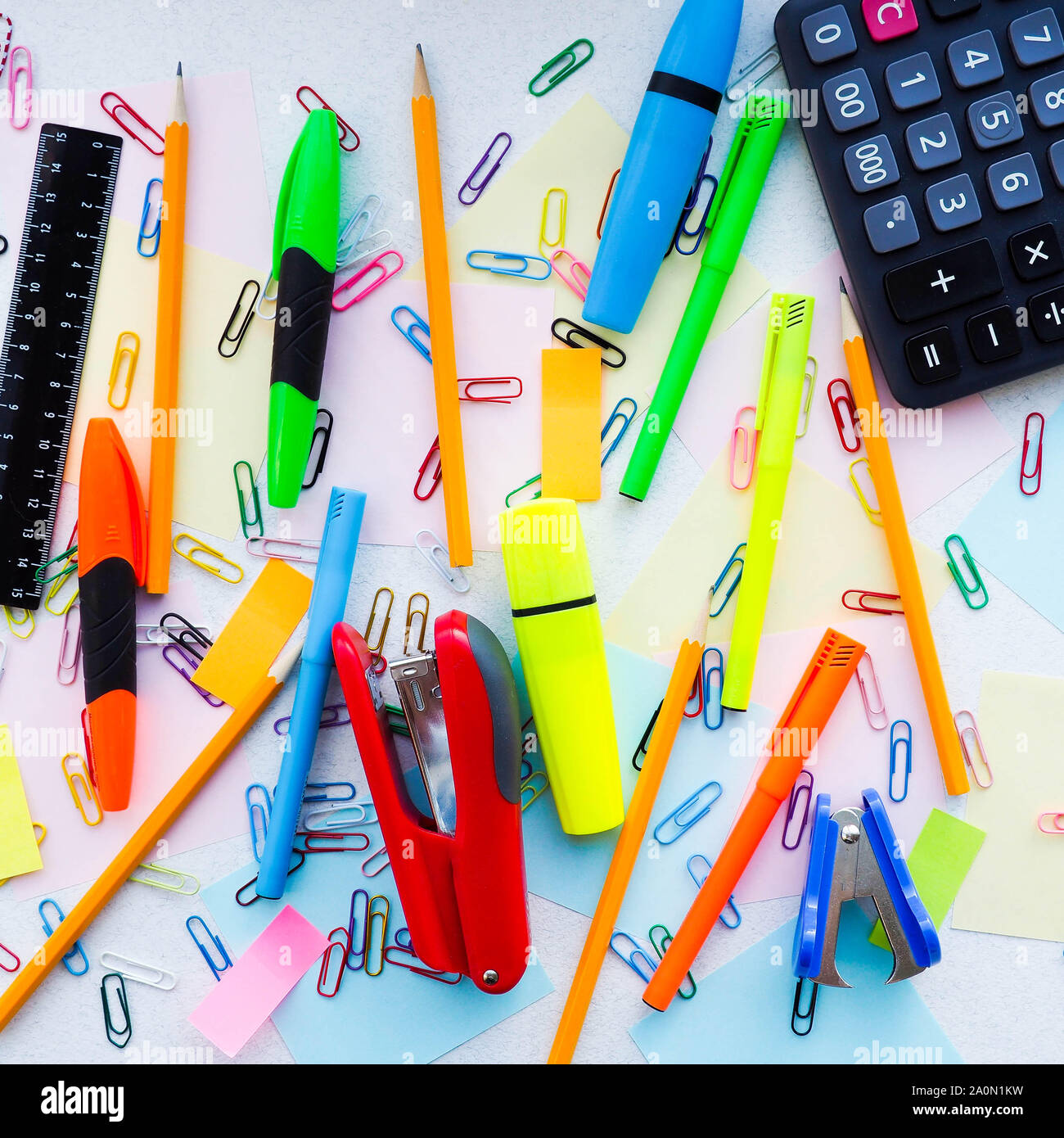 stationery stapler, paper clips, notes, pens and pencils on the table ...