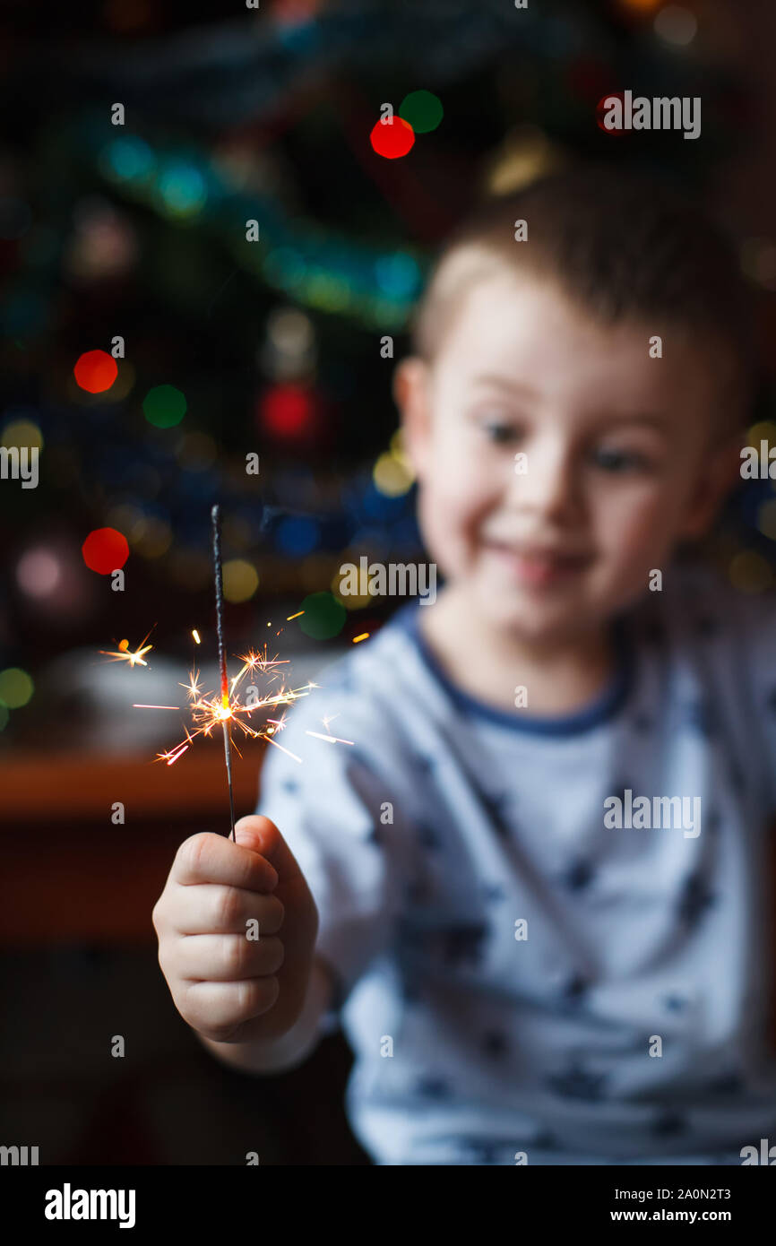 Beautiful Little child holding burning sparkler on New Year's Eve ...