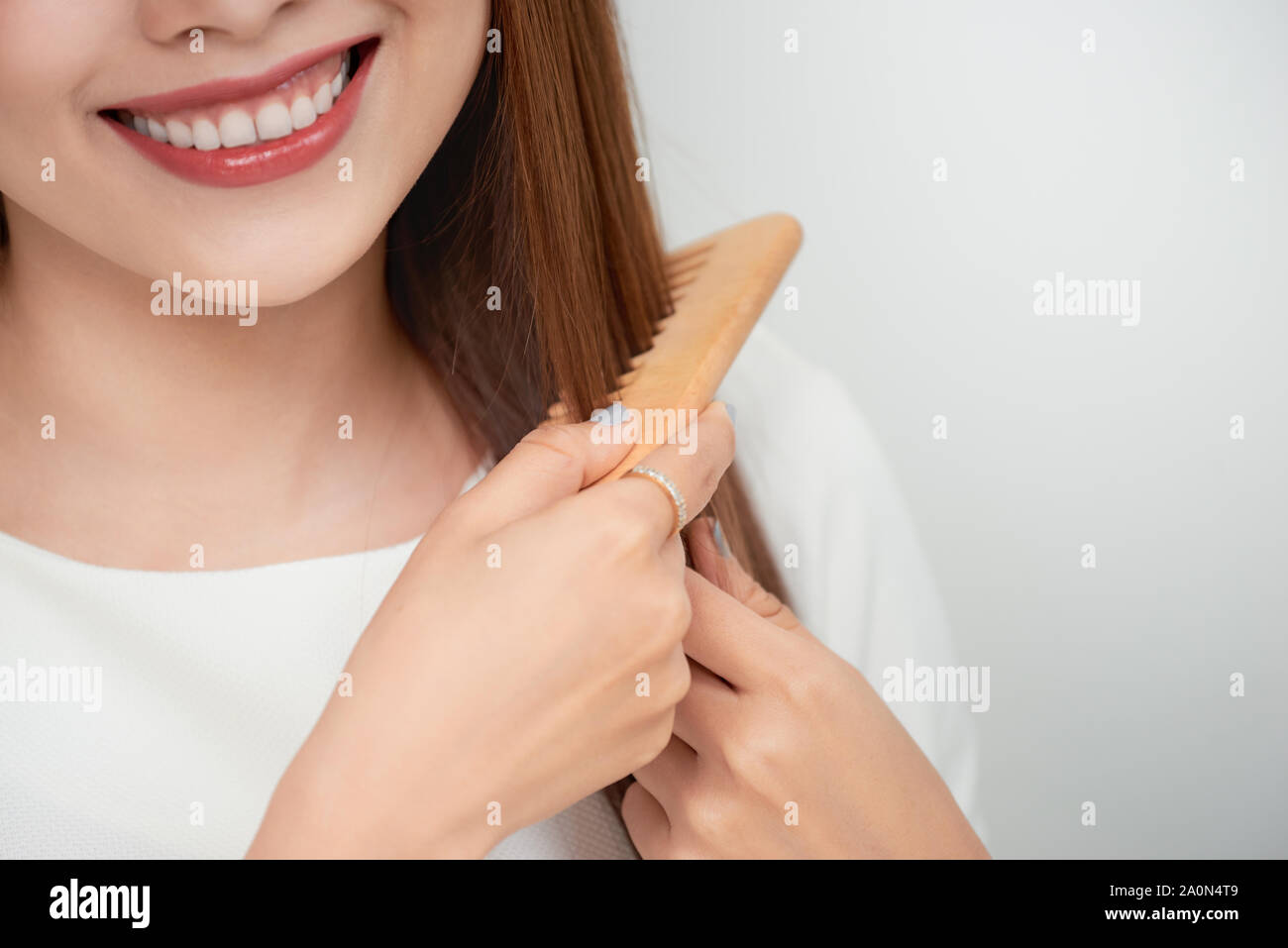 Isolated portrait of a beautiful young woman comb long hair Stock Photo ...
