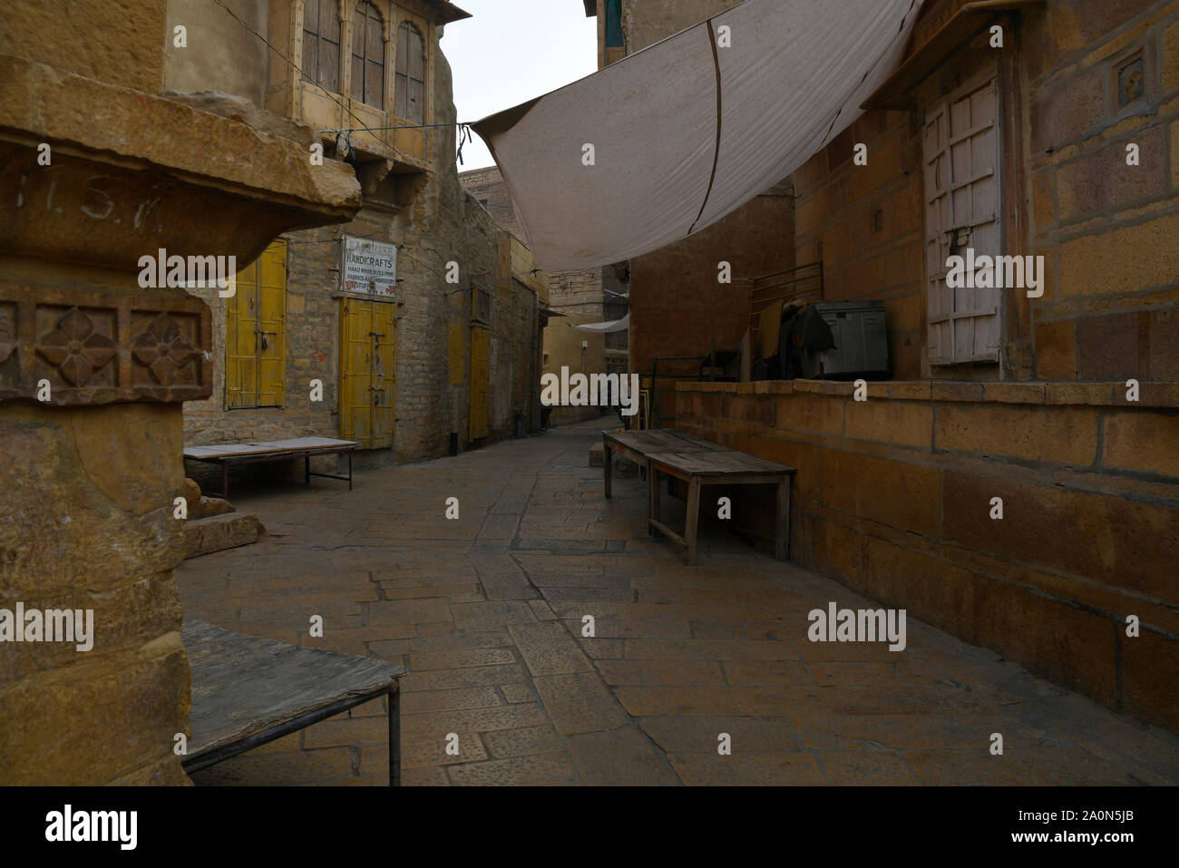 Narrow typical road with stone walls and stone pavements inside golden ...