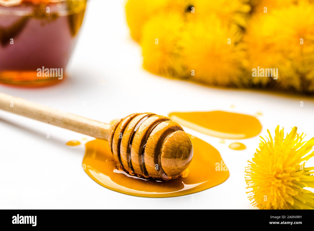 Dandelion honey - stick with drop of honey on white background Stock ...